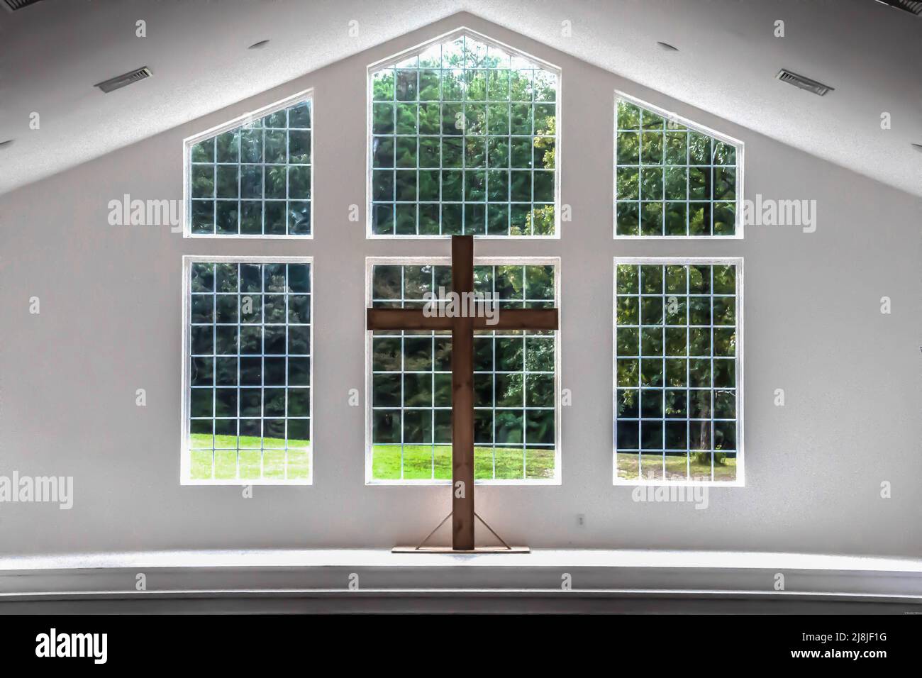 A lone cross in a solitary white room well lit by a single window Stock ...