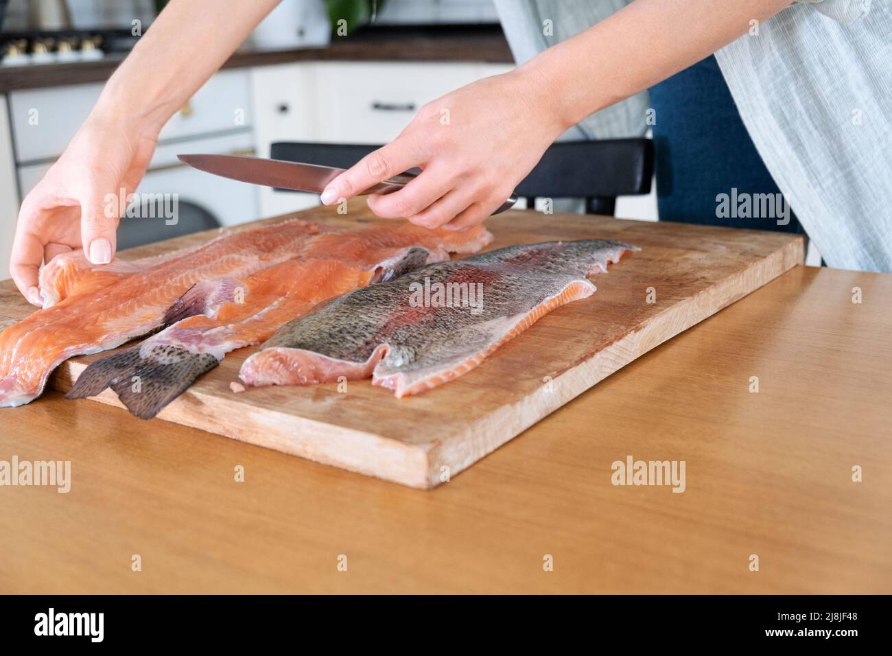 Female hands cutting fillet of red fish. Red caviar. Removing fish ...