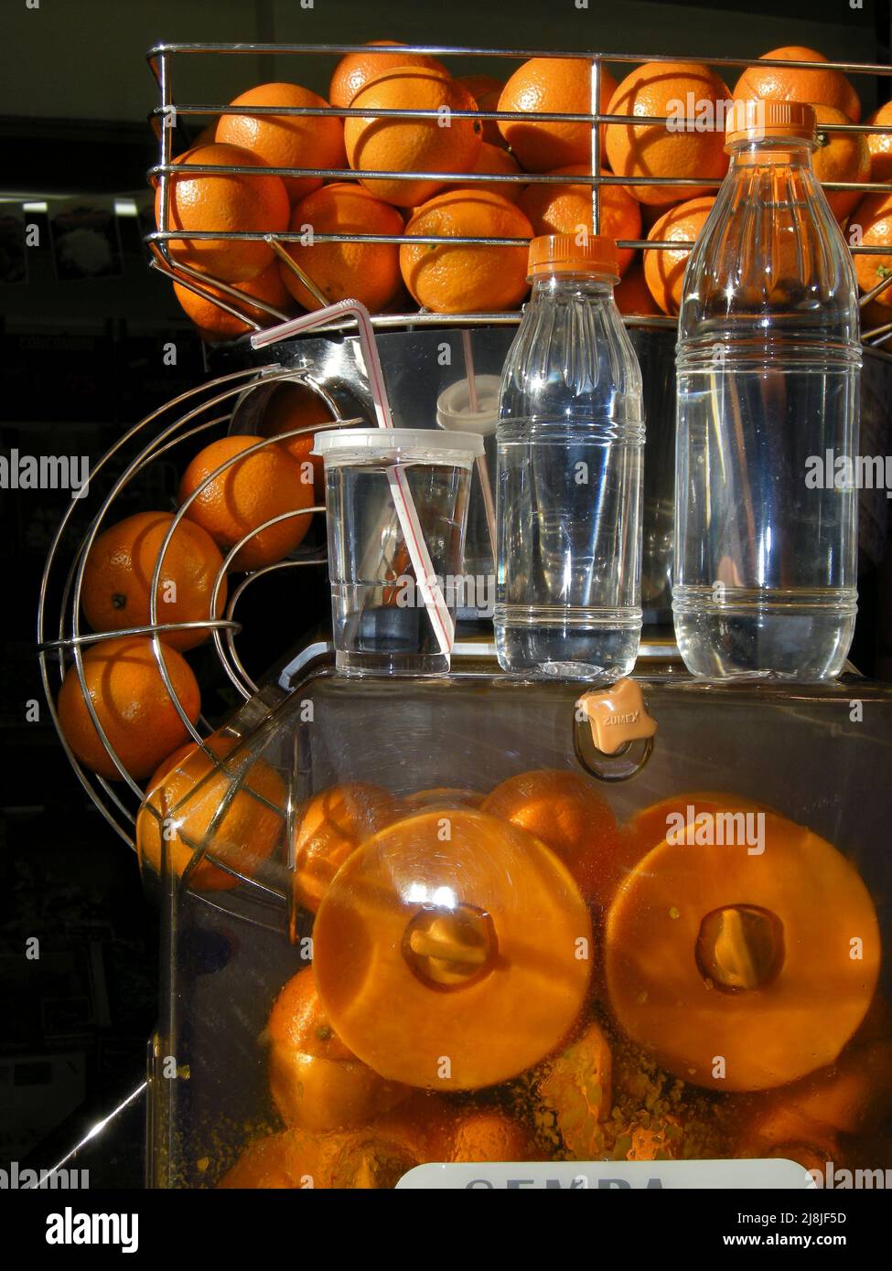 Oranges lined up in a machine for making fresh-squeezed orange juice at ...