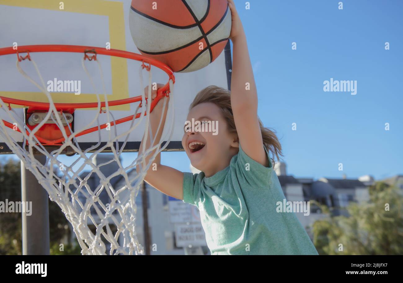 Close up image of basketball excited kid player dunking the ball ...
