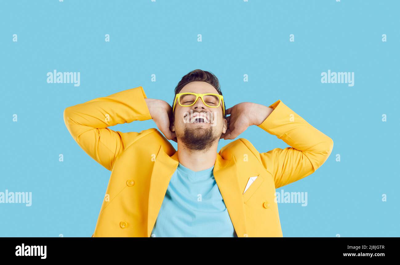 Happy man in yellow jacket, blue T shirt and glasses relaxing with his ...