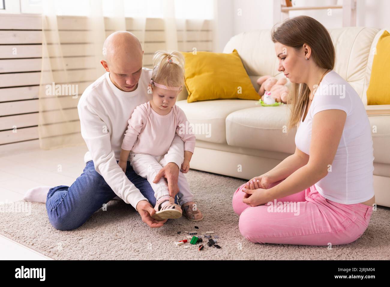 Cochlear implant on the child girl head and playing with mother and ...