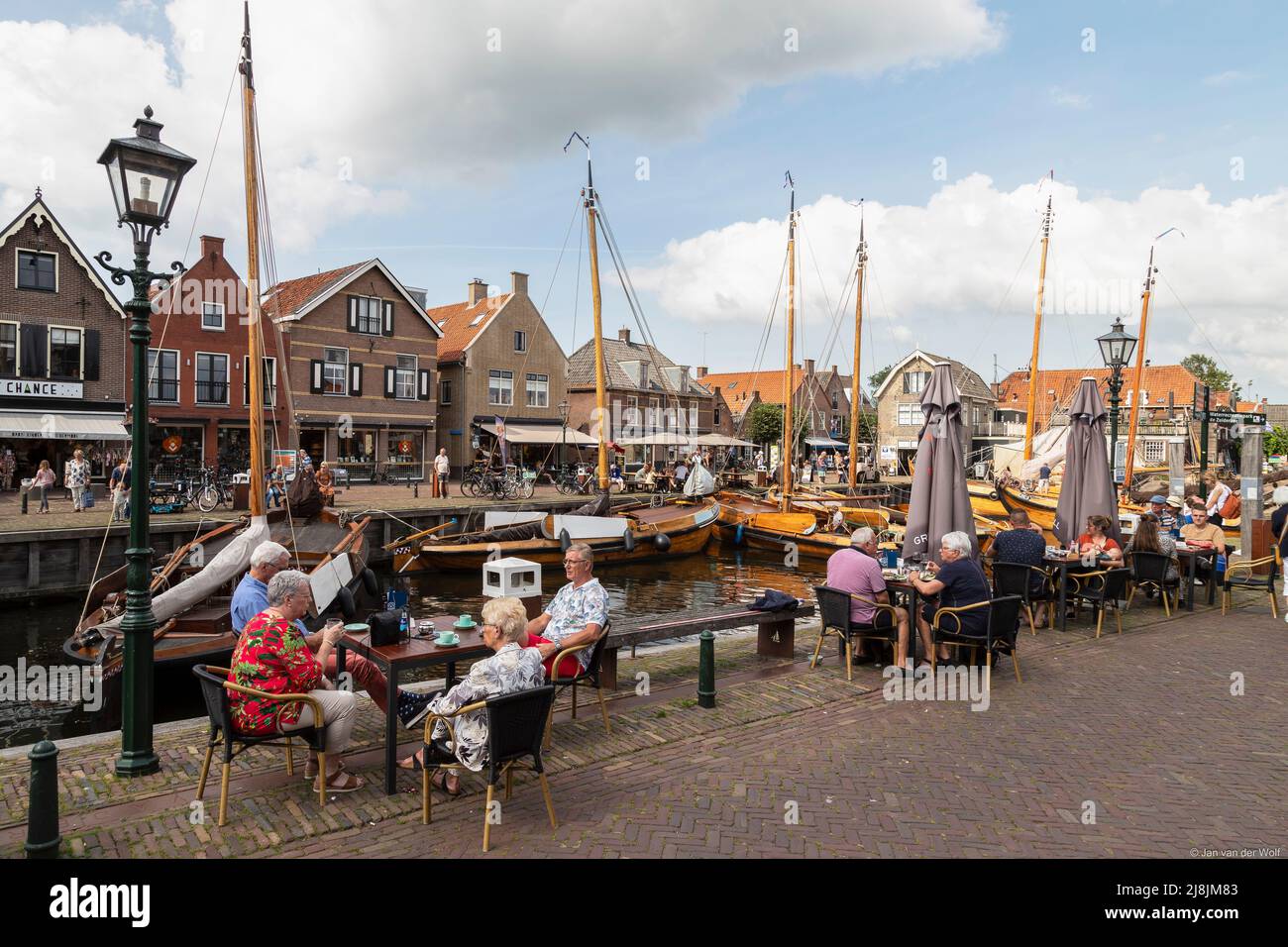 People enjoy on the terrace at the harbor of the fishing village ...