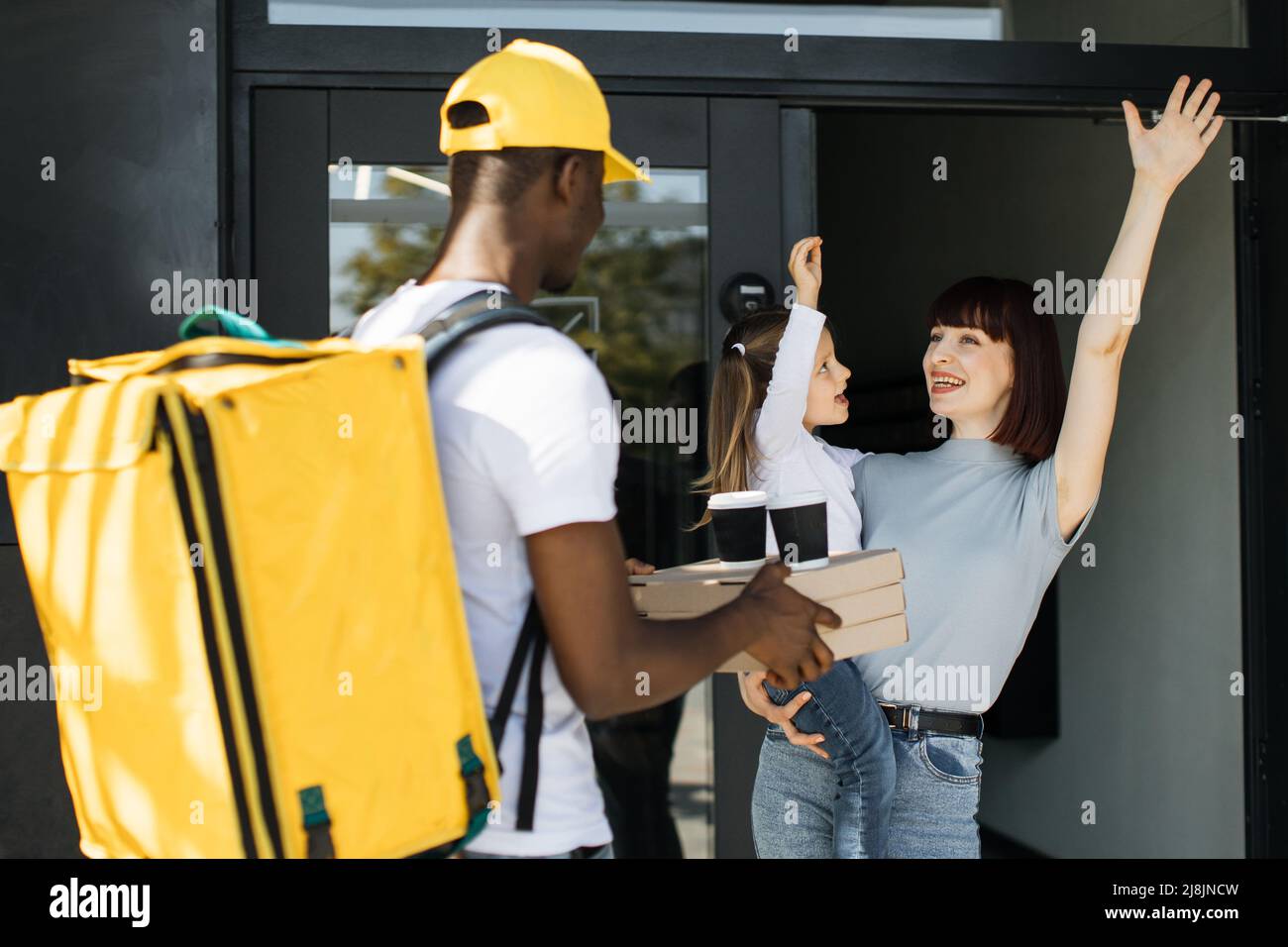 Male african courier giving pizza boxes and takeaway coffee from ...