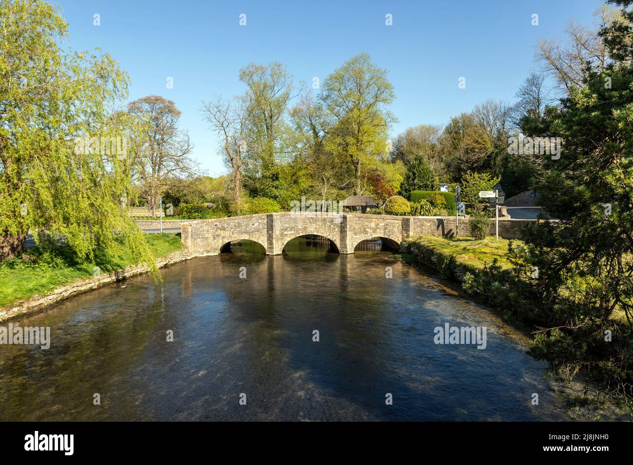 Old stone bridge over River Coln, flowing through the Cotswolds village ...