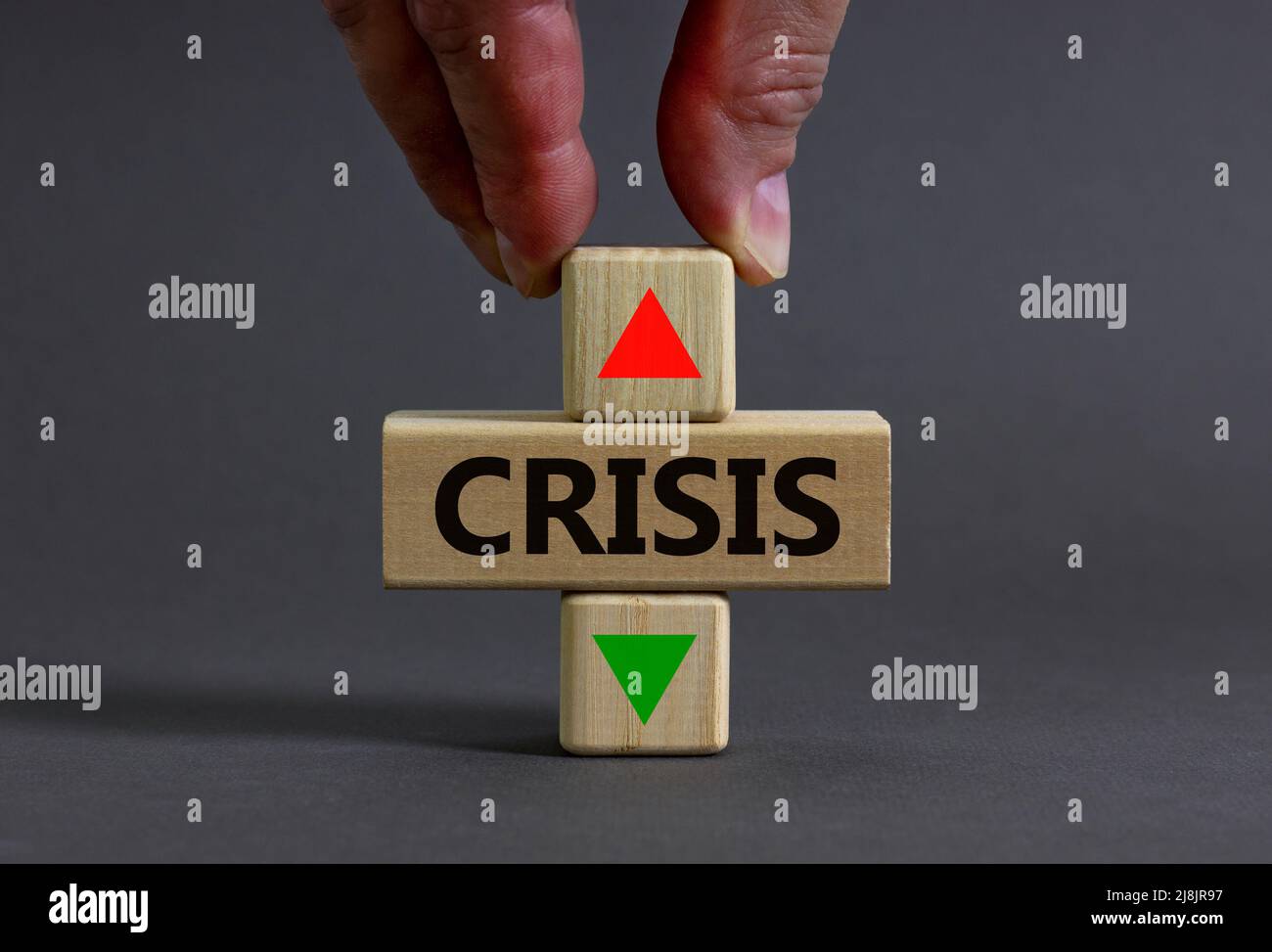 Time to crisis symbol. Businessman holds a wooden cubes with up icon ...