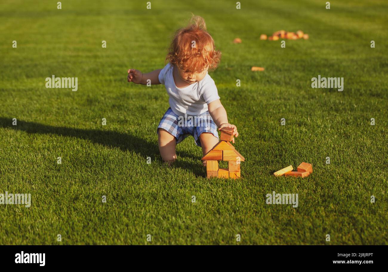Little child play in park. Portrait of a happy baby in grass field ...