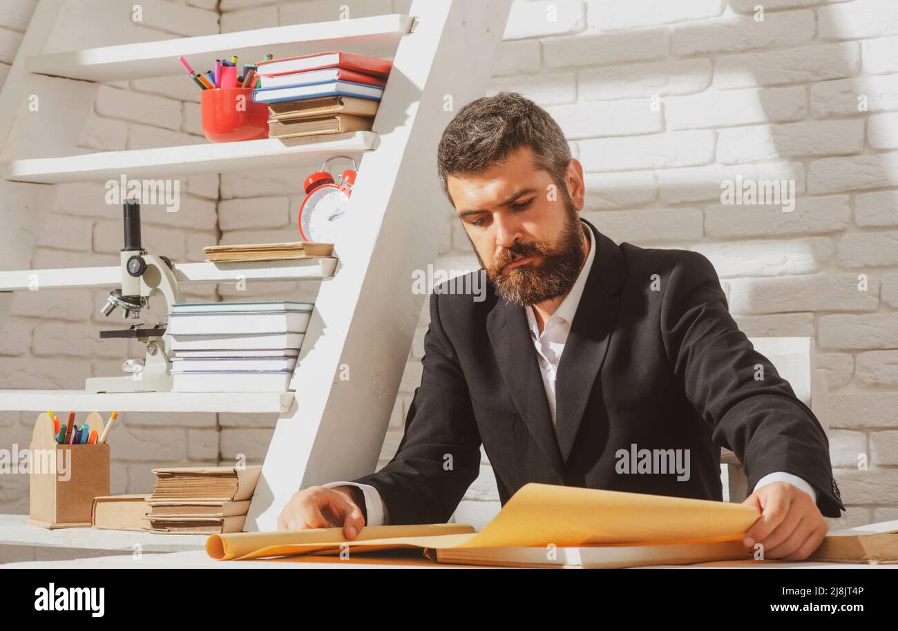 Portrait Of Male Teacher Working At Desk In Class Tutor Professor Mentor Man At Desk