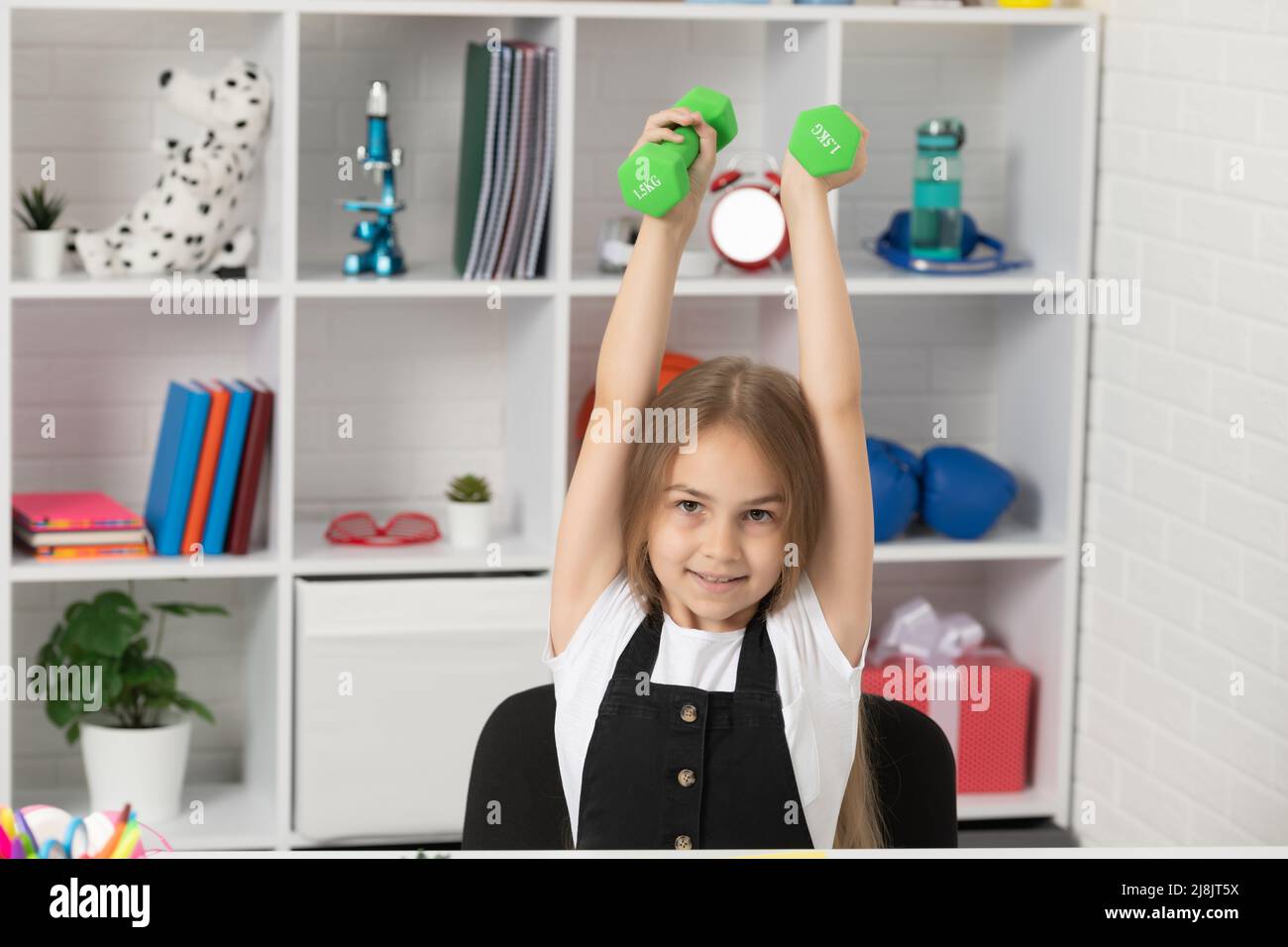cheerful child hold barbells in school classroom Stock Photo - Alamy