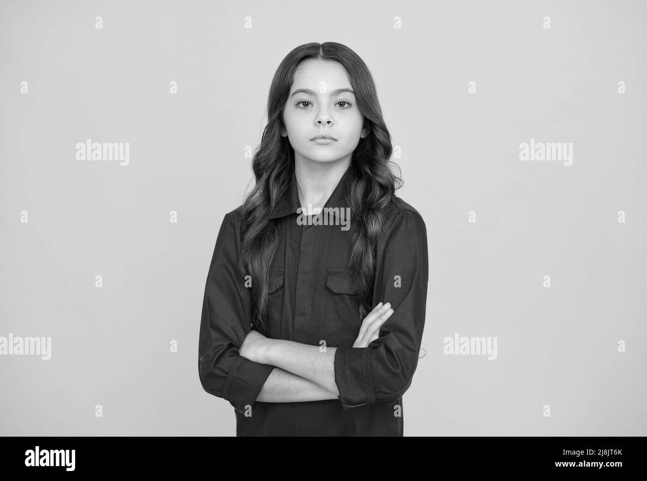 confident and serious teenager girl in red shirt crossed hands ...