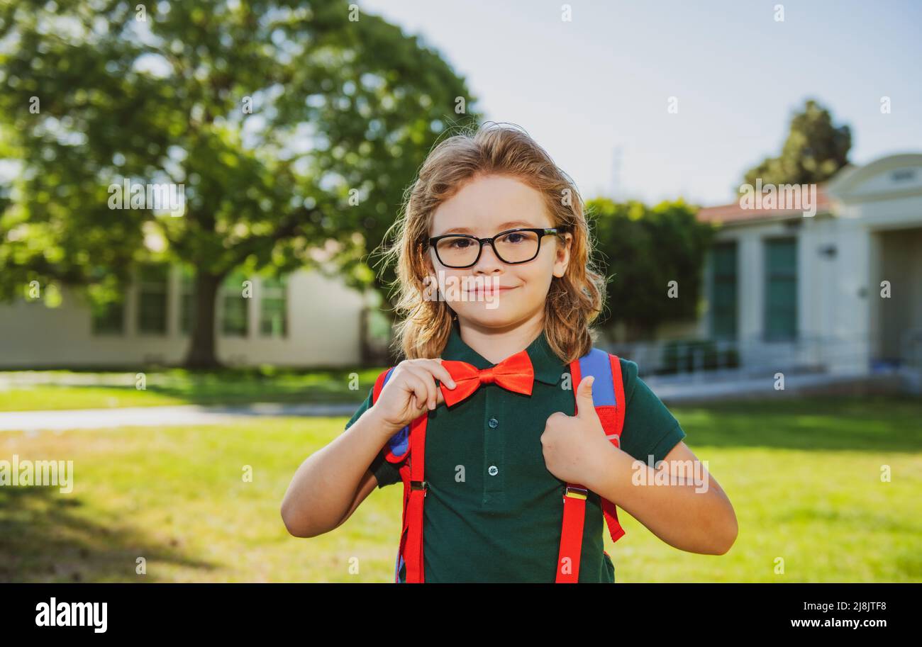 Cheerful little school boy in school uniform with backpack standing ...