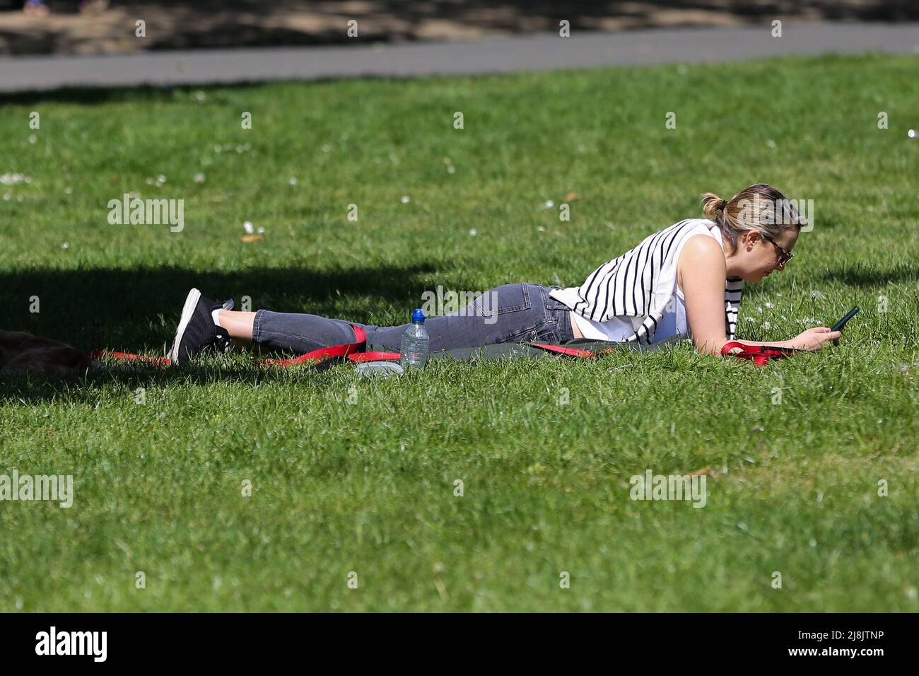 A woman enjoys the warm and sunny weather in London Stock Photo - Alamy