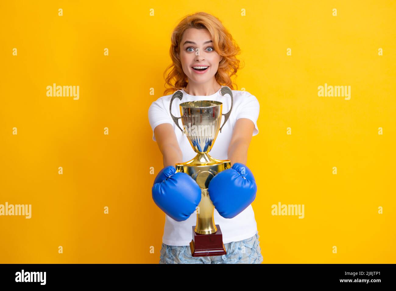 Cheerful woman celebrating victory. Woman in boxing gloves hold ...