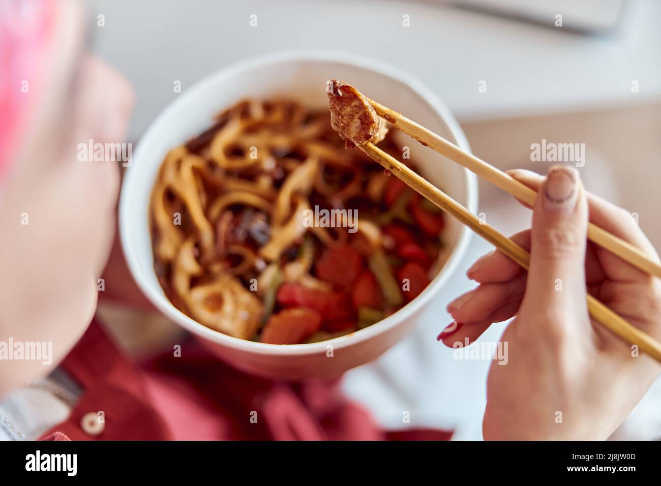 Asian guy holding chopsticks of instant noodles in paper bowl Stock ...