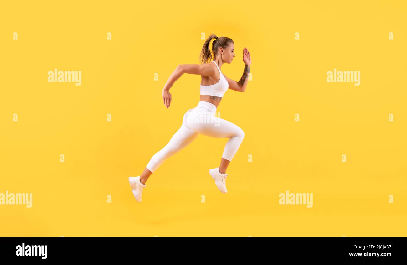 fitness woman runner running on yellow background Stock Photo - Alamy
