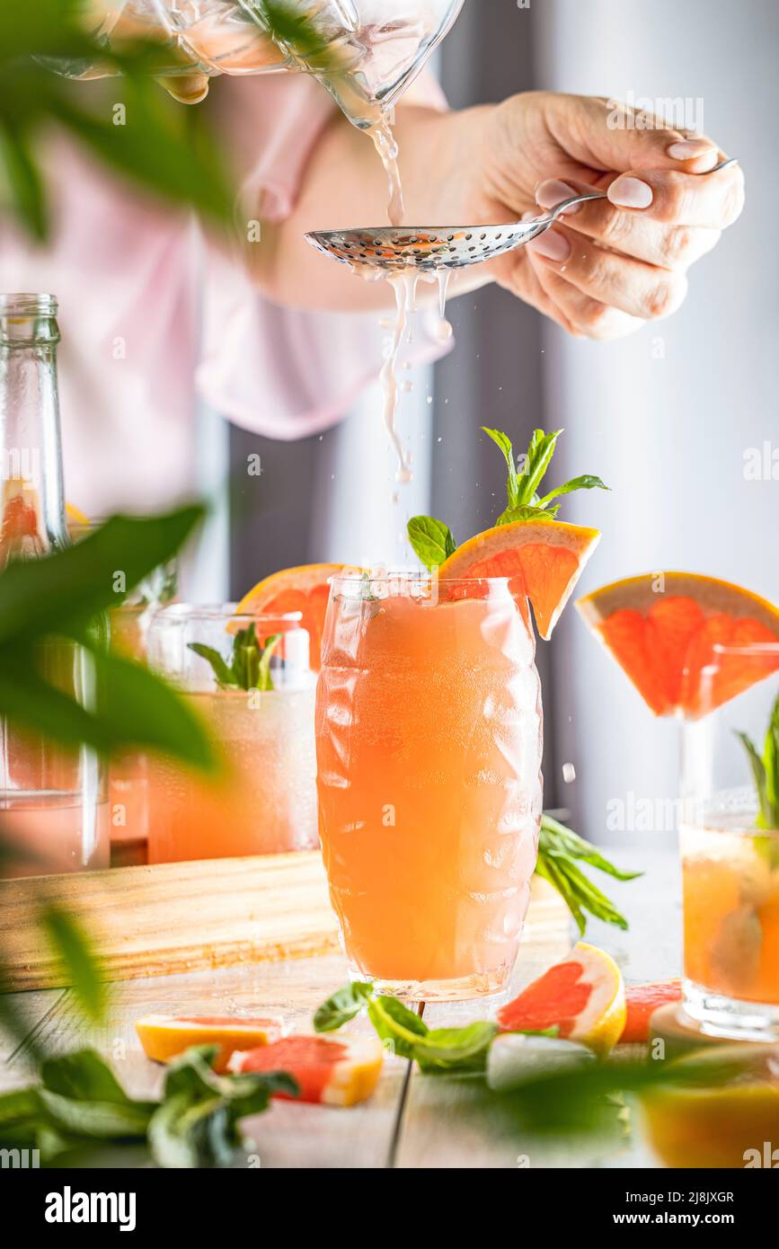 Real woman preparing Grapefruit Cocktail in highball glass or mocktails ...