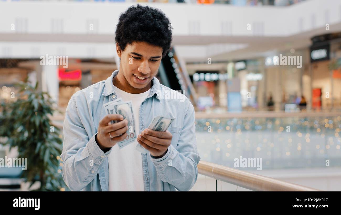 Happy african successful business man counting money standing indoors ...