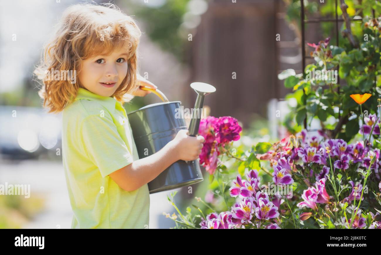 Child pouring water on the trees. Kid helps to care for the plants in ...