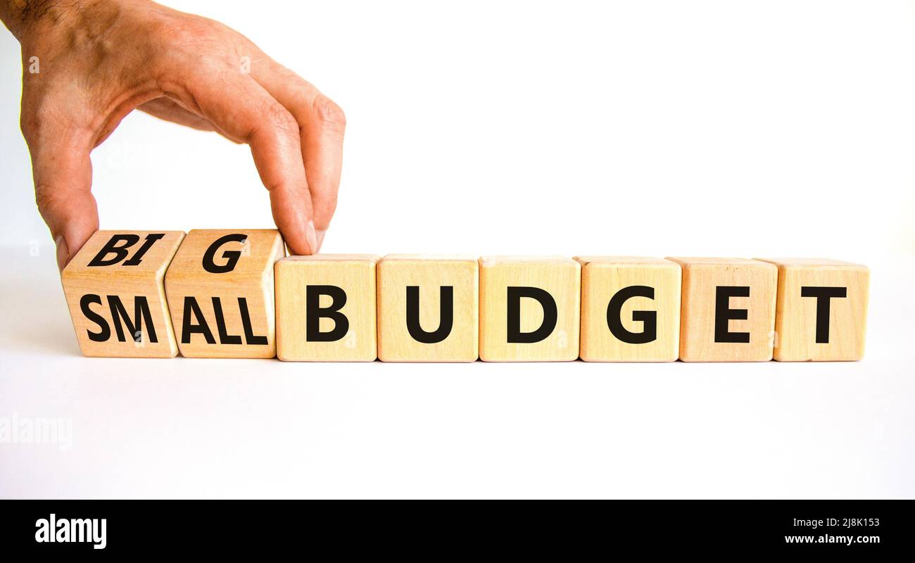 Big or small budget symbol. Businessman turns wooden cubes and changes ...