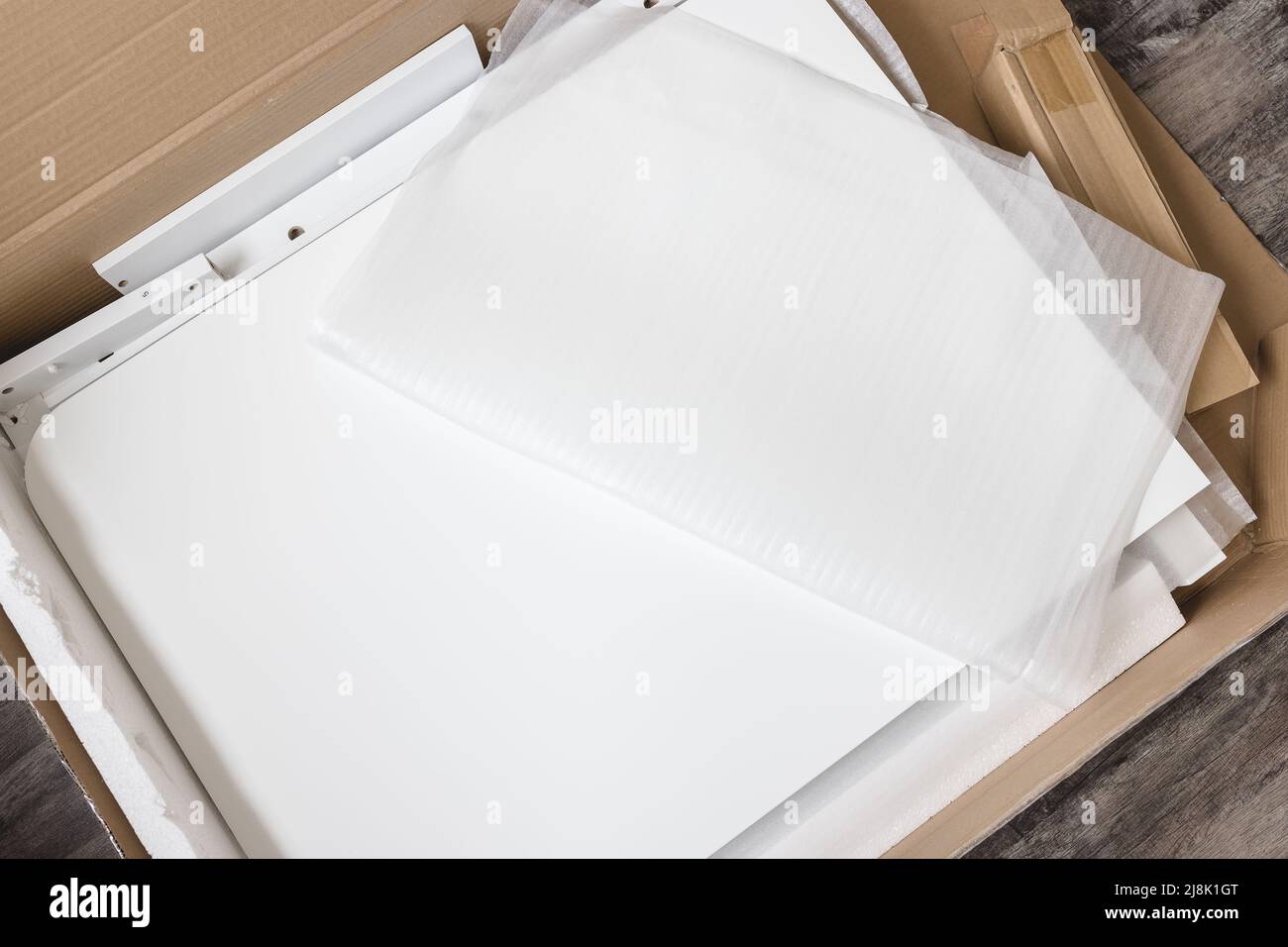 Opened box with furniture assembly drawer parts of and tools on the ...