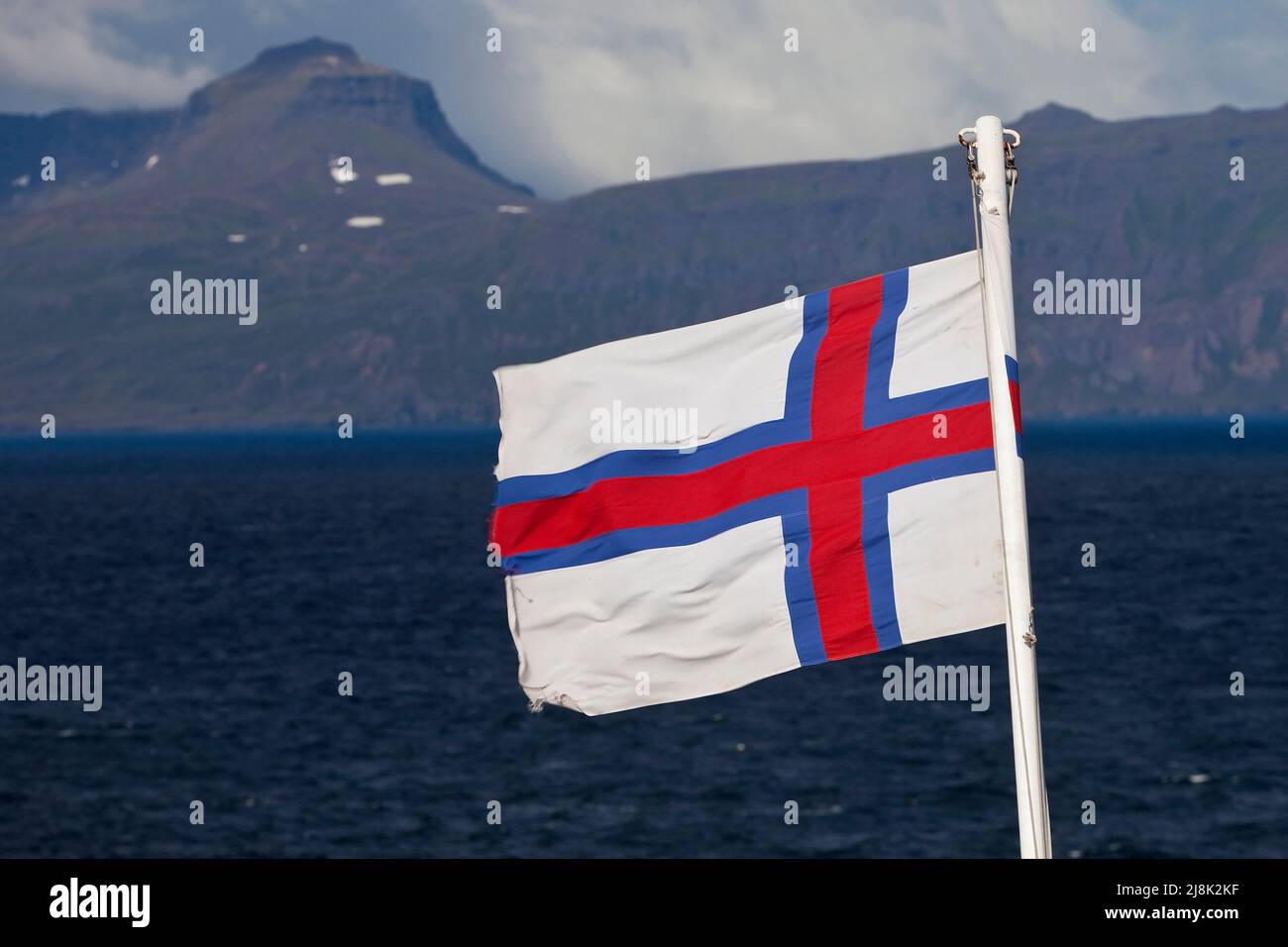 Flag of the Faeroe Islands on ferry Norroena in front of the Atlantic ...