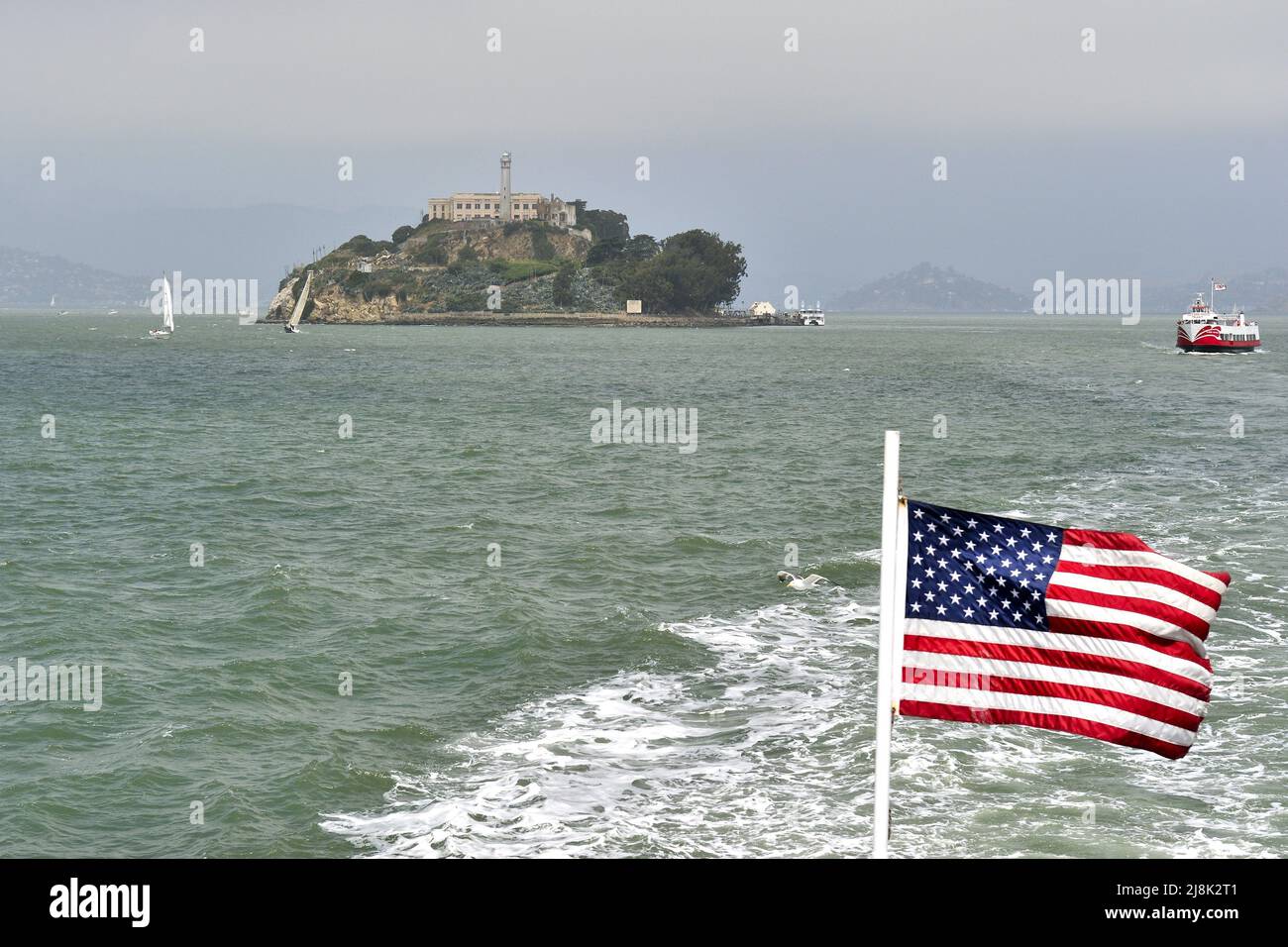 Prison Island Alcatraz seen from the ferry, with American flag, USA ...