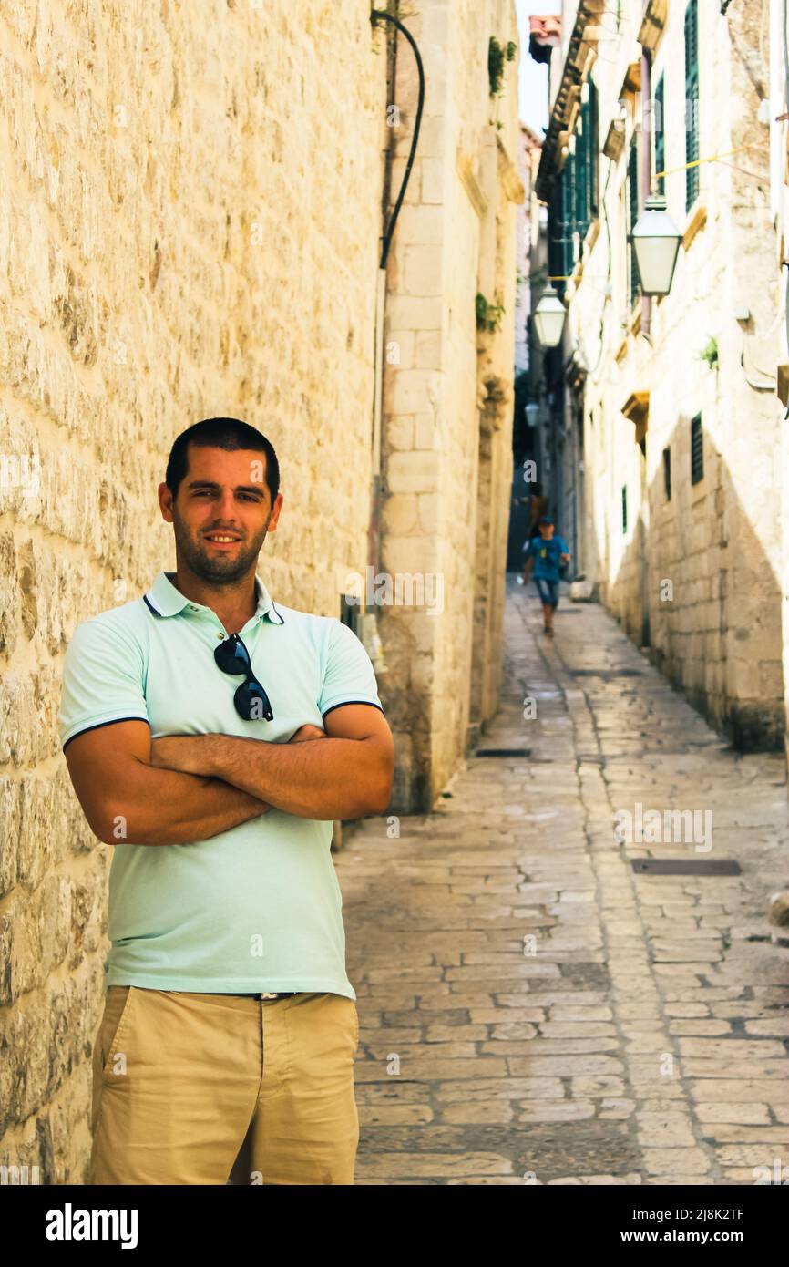 A handsome young man in narrow street in the Old Town of Dubrovnik ...