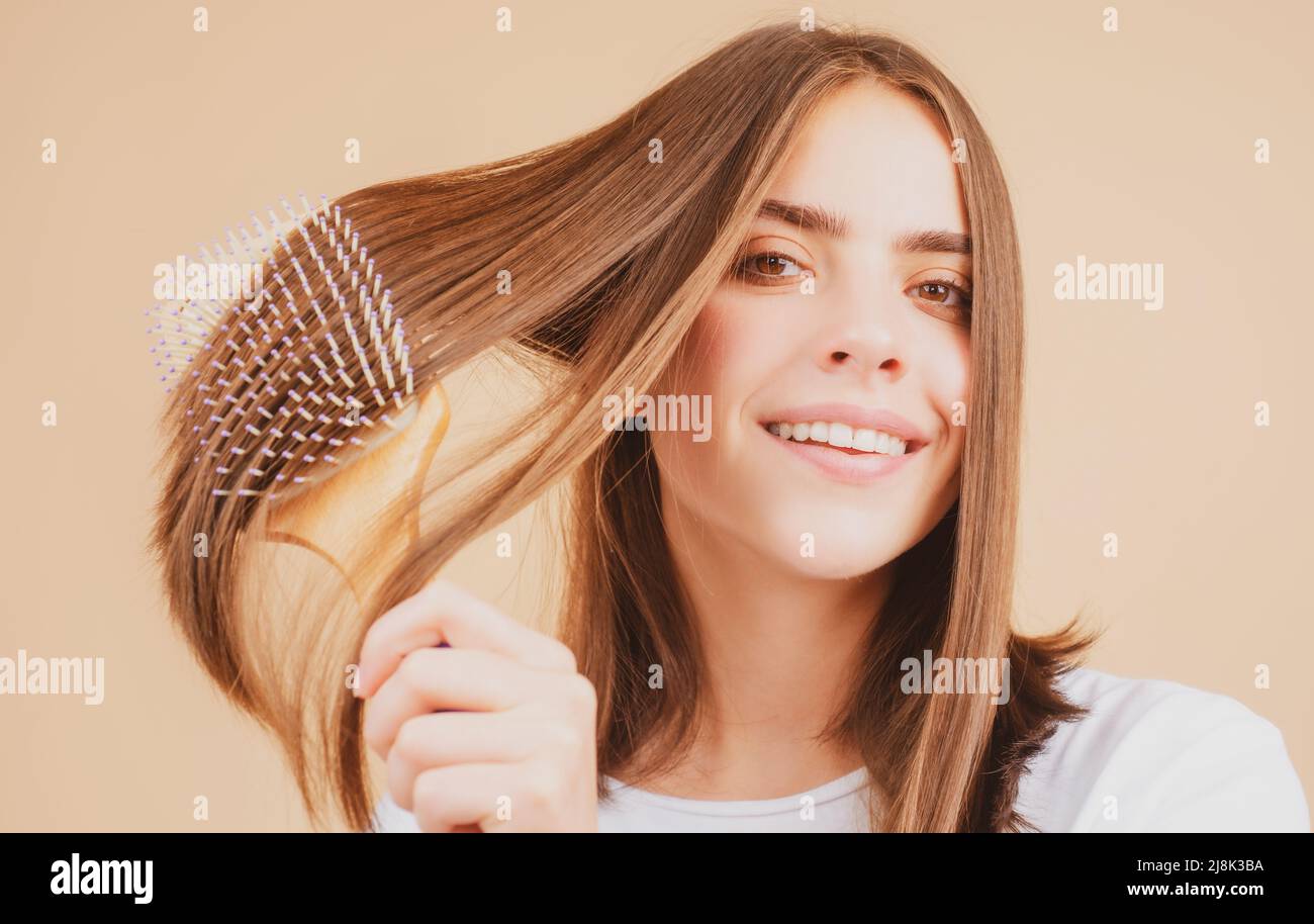 Woman is making hairstyle with comb. Beautiful young woman holding ...
