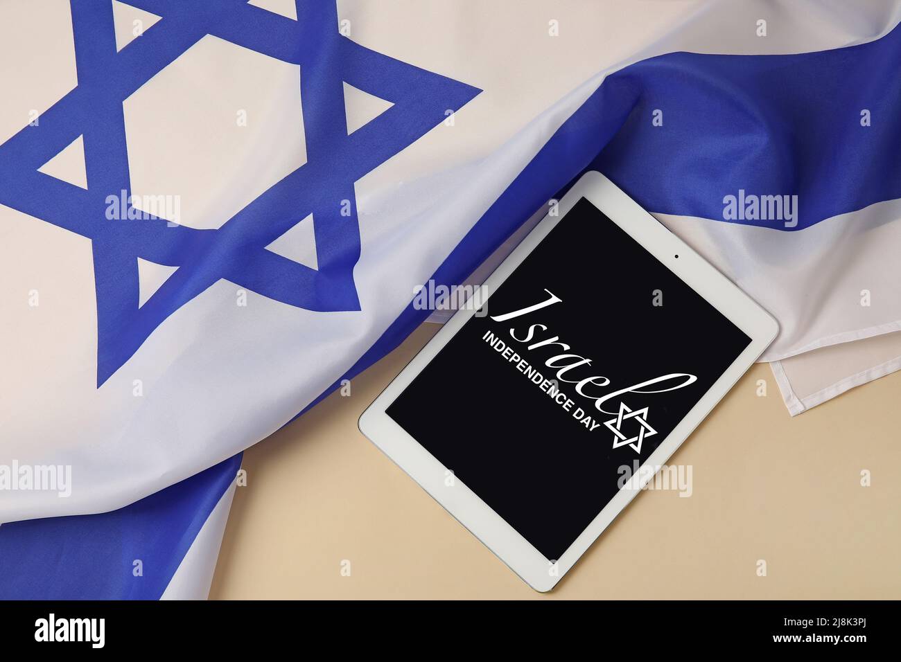 Tablet computer with text ISRAEL INDEPENDENCE DAY on screen and flag on ...