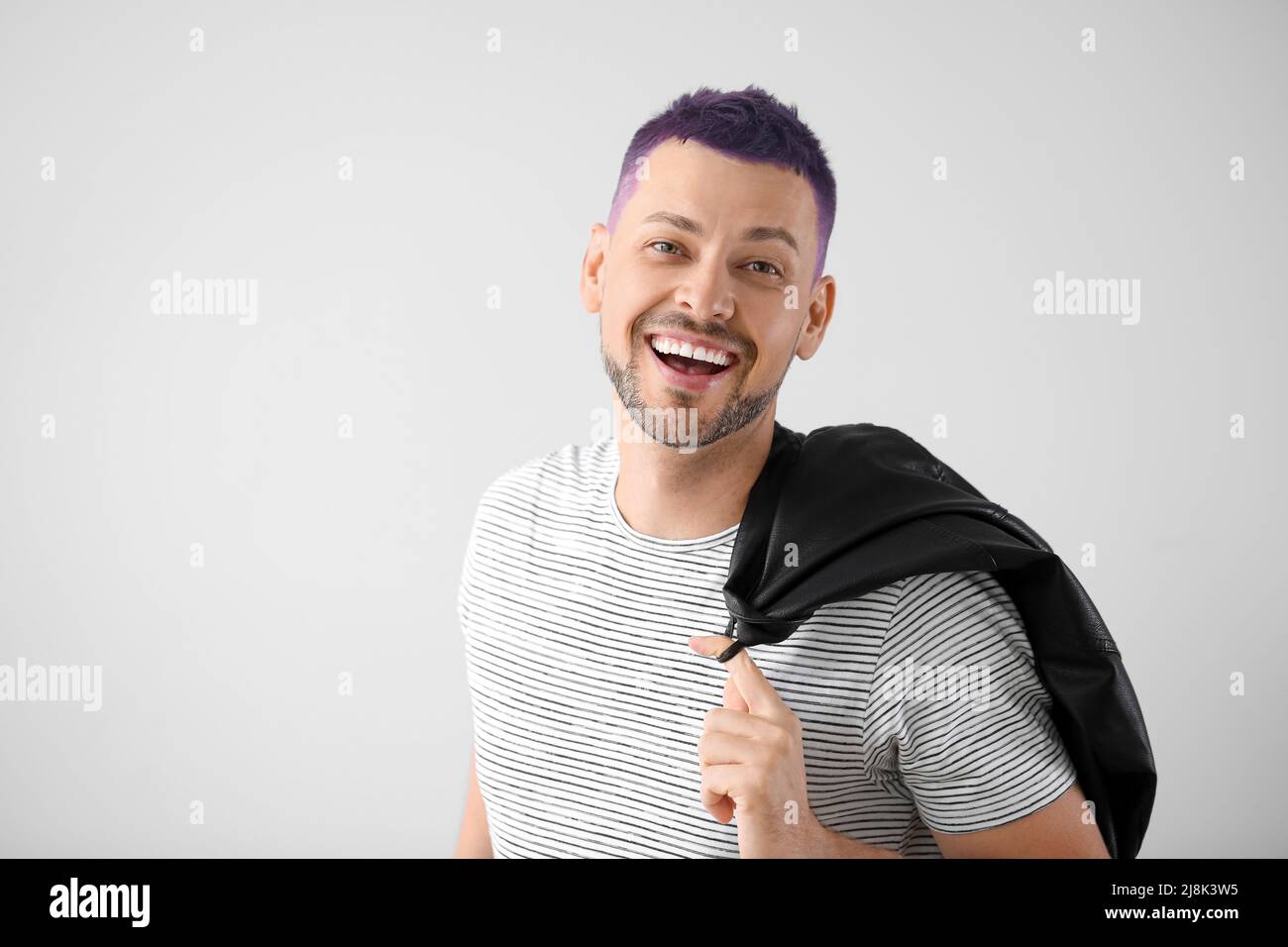 Happy stylish man with unusual violet hair on light background Stock ...