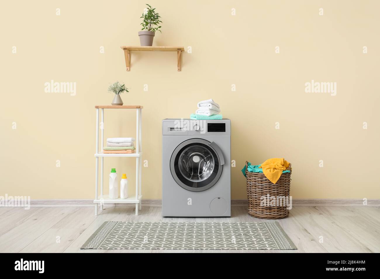 Interior of modern home laundry room with washing machine, basket and ...