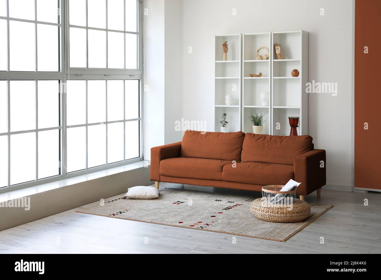 Interior of modern room with shelf unit and sofa near window Stock ...
