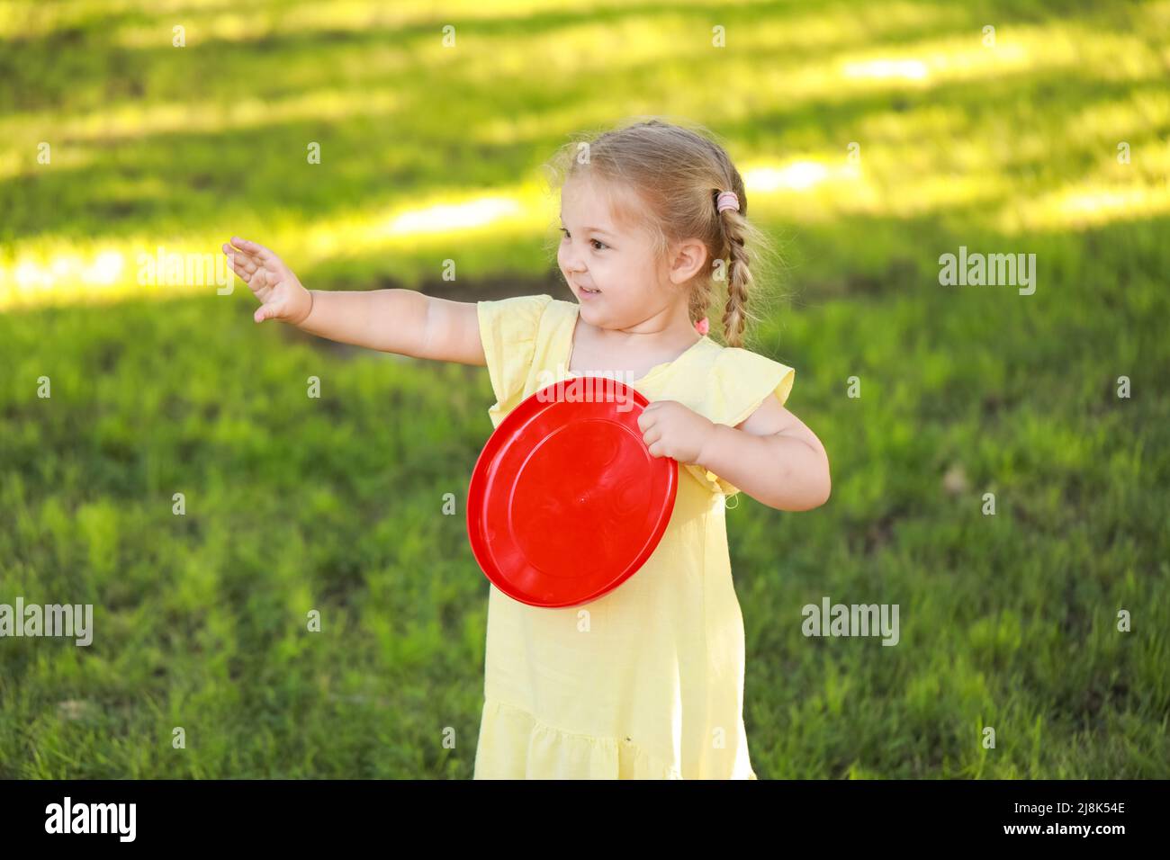 Cute little girl playing frisbee in park Stock Photo - Alamy