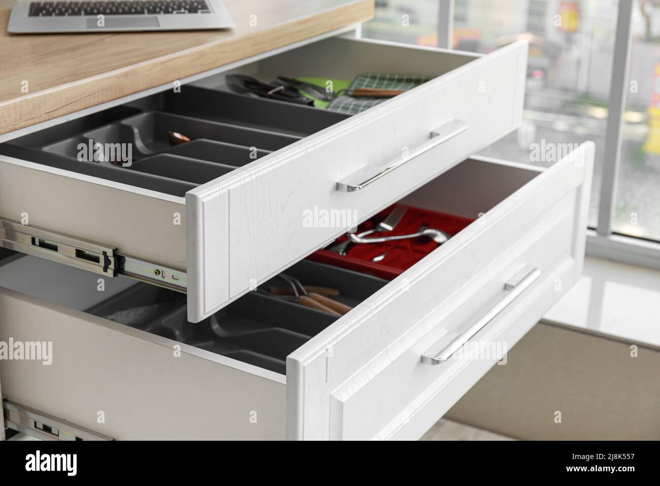 Open drawers with cutlery in modern kitchen Stock Photo - Alamy