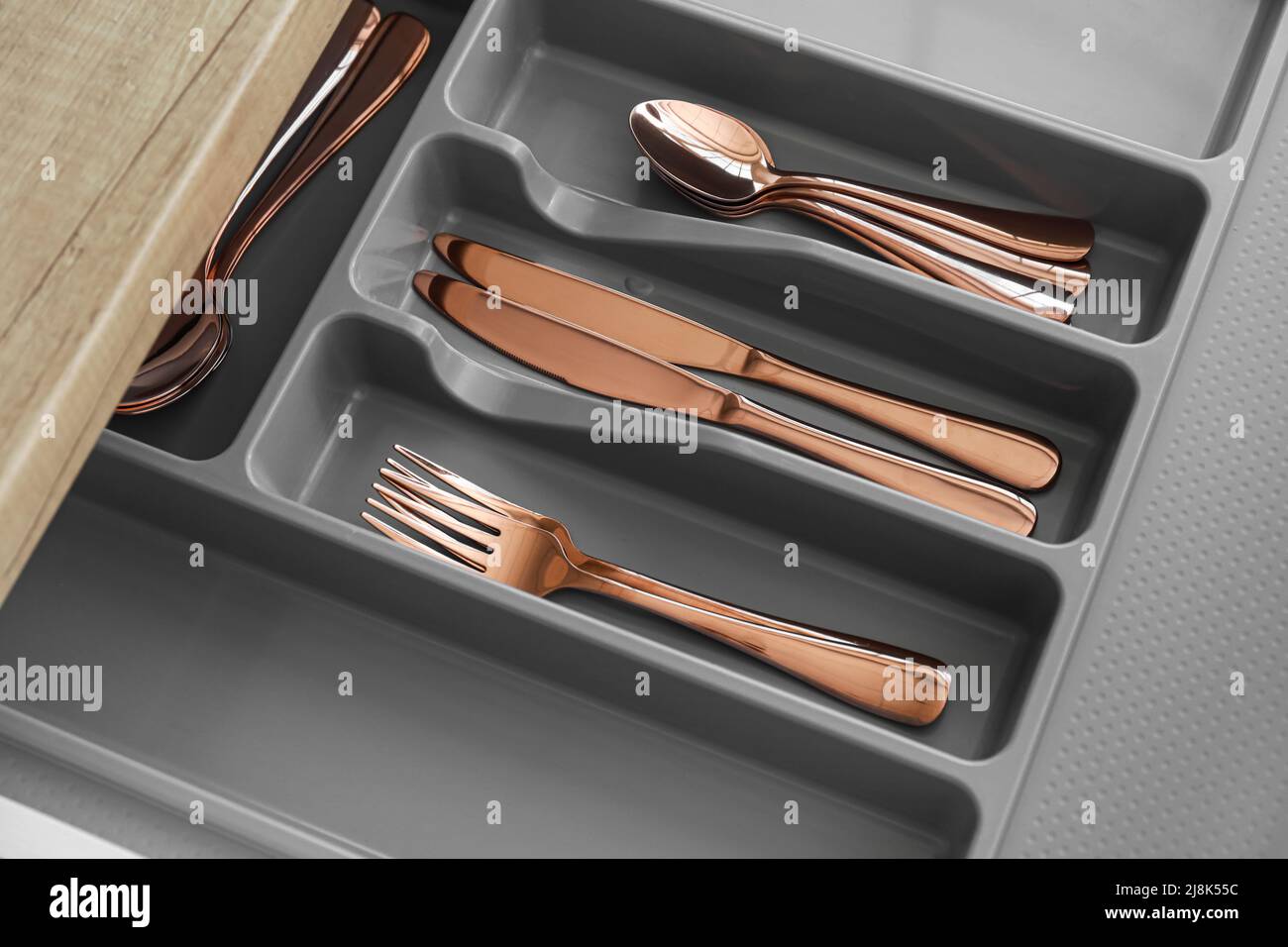 Open drawer with golden cutlery in modern kitchen Stock Photo - Alamy