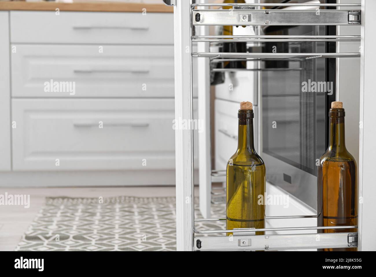 Drawer with bottles of wine in modern kitchen Stock Photo - Alamy