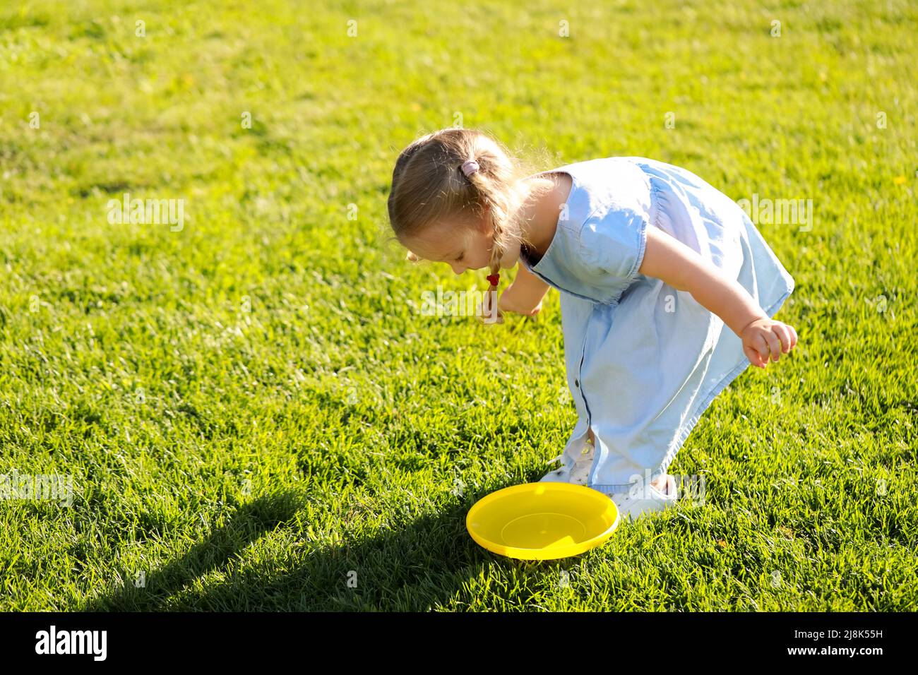 Cute little girl in dress playing frisbee in park Stock Photo - Alamy