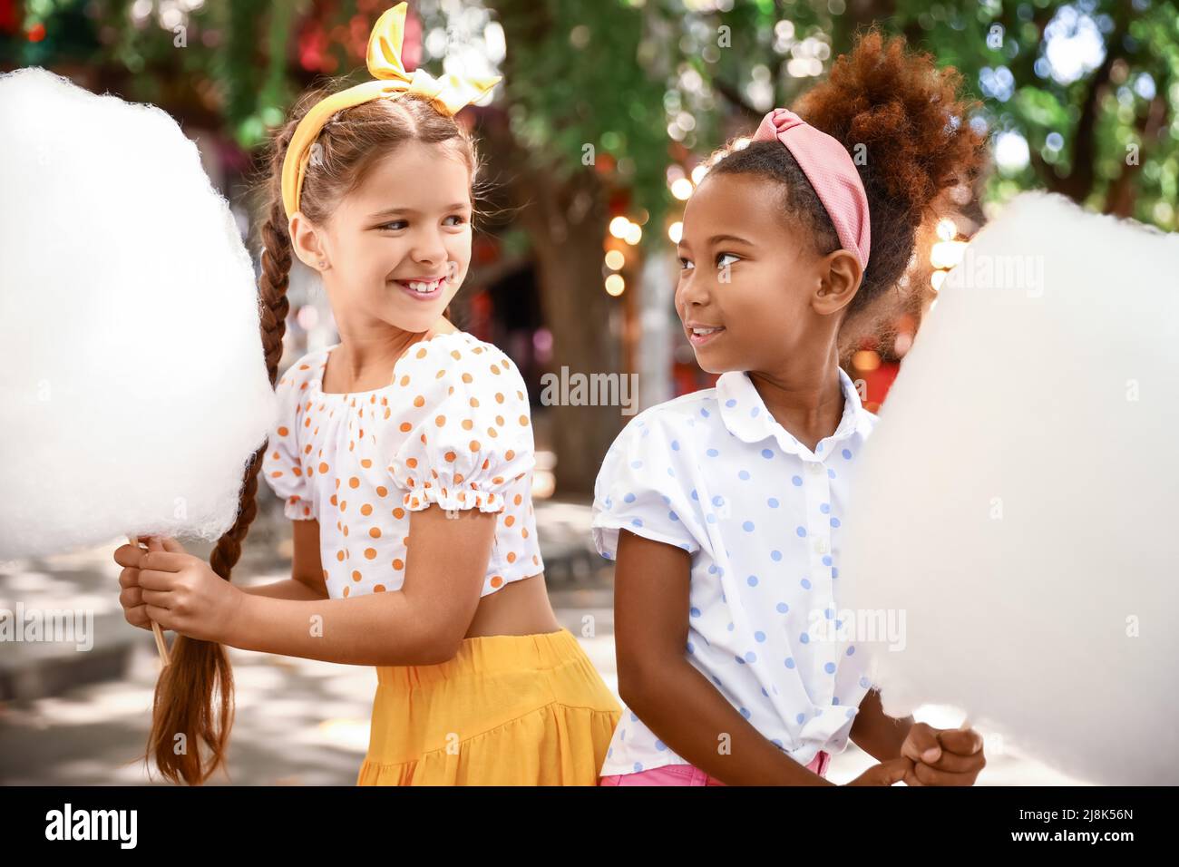 Cute little girls with cotton candy outdoors Stock Photo - Alamy