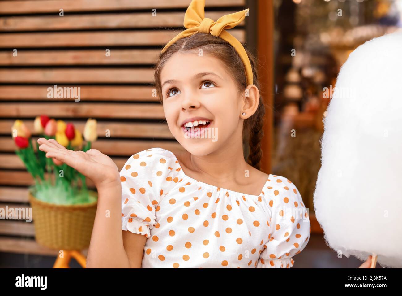Cute little girl with cotton candy outdoors Stock Photo - Alamy