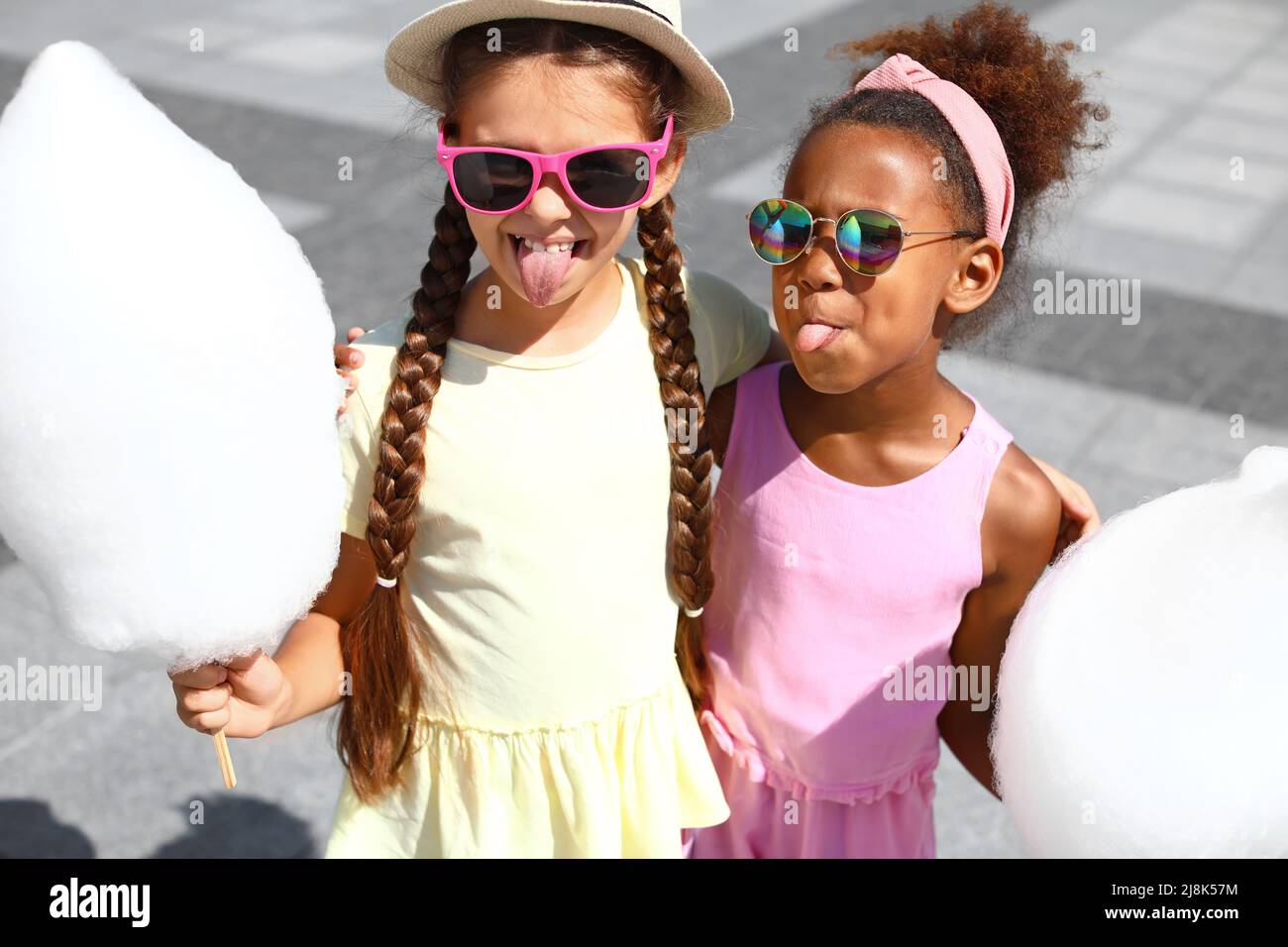 Cute little girls with cotton candy outdoors Stock Photo - Alamy