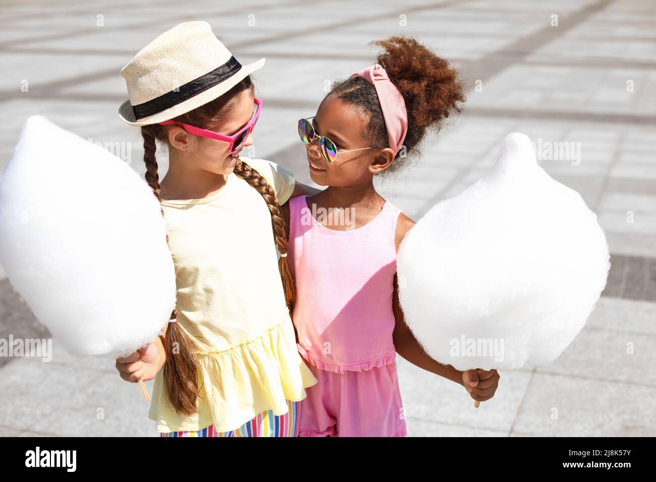 Cute little girls with cotton candy outdoors Stock Photo - Alamy