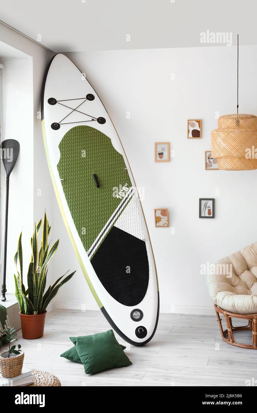 Stylish interior of room with sup board, chandelier and armchair Stock ...