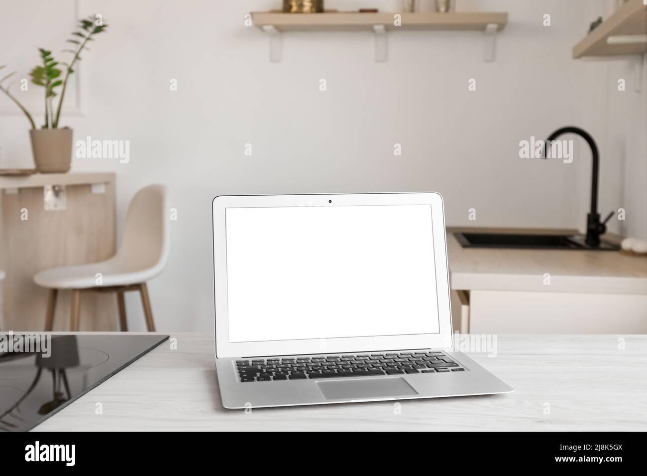 Laptop with blank screen on counter in light kitchen Stock Photo - Alamy