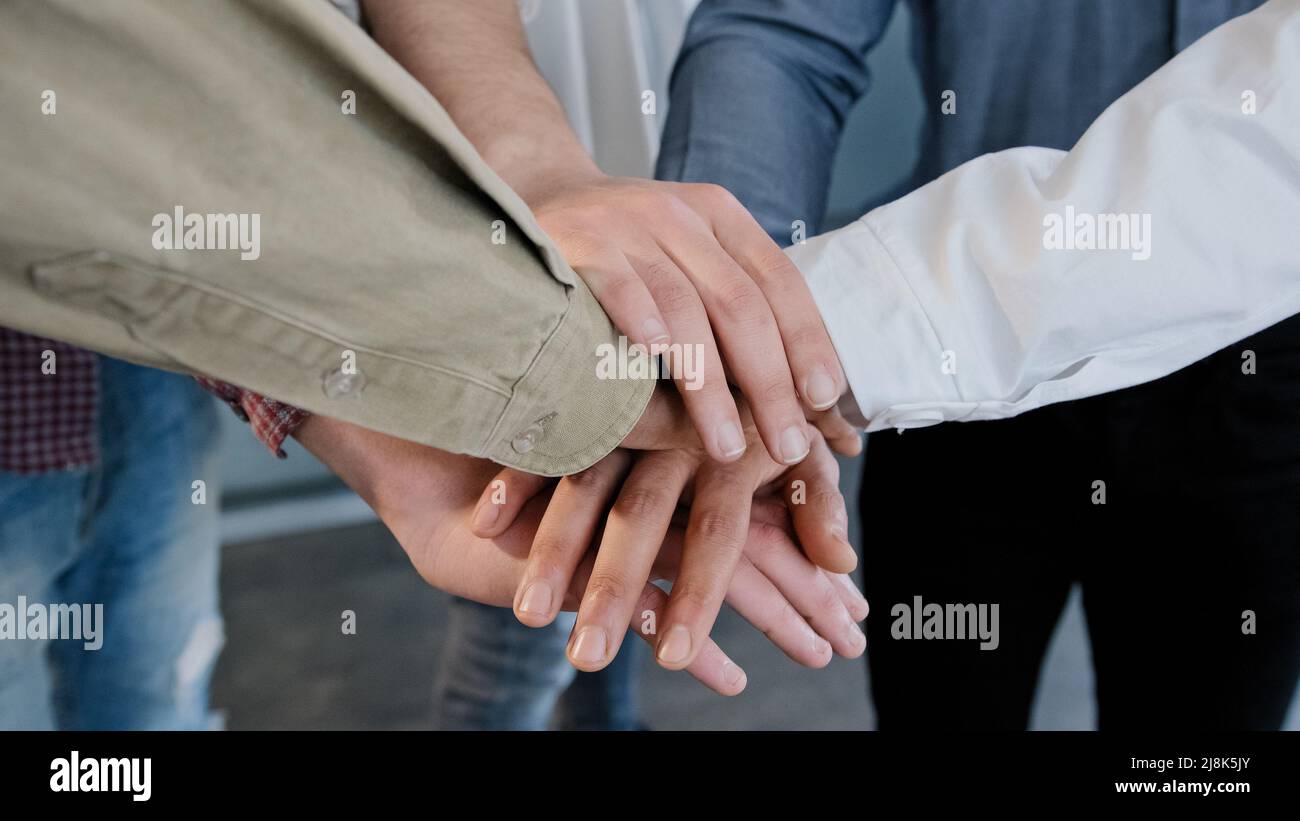 Close-up group unrecognizable people team fold hands put palms together ...