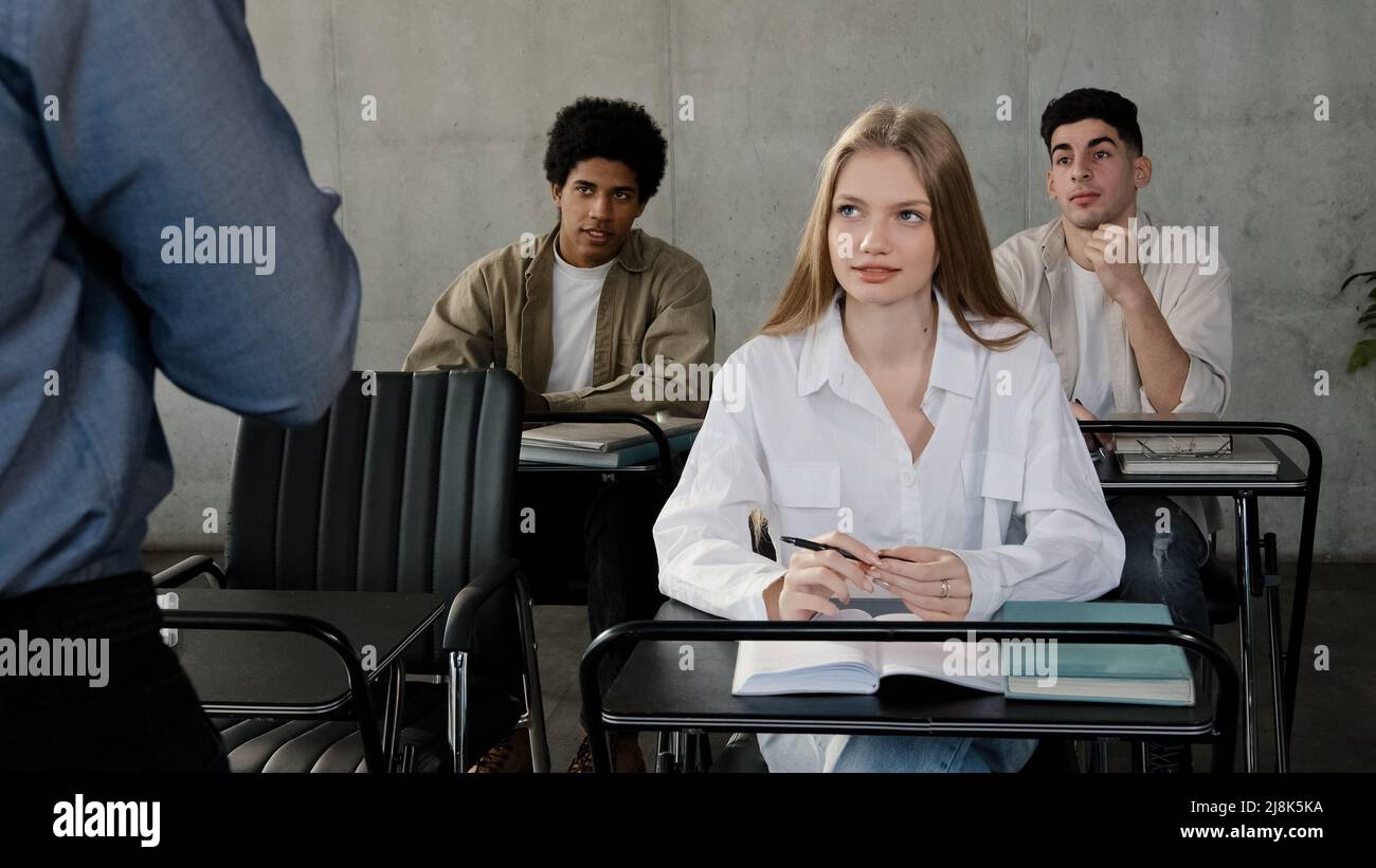 Diverse team young people sitting in classroom attentively listening ...