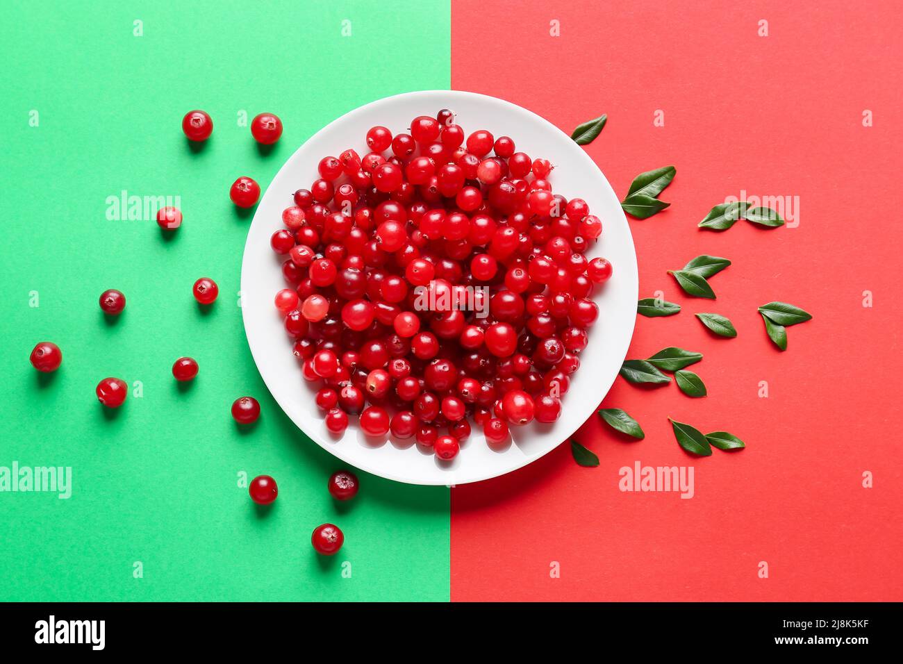 Plate with lingonberries and leaves on color background Stock Photo - Alamy