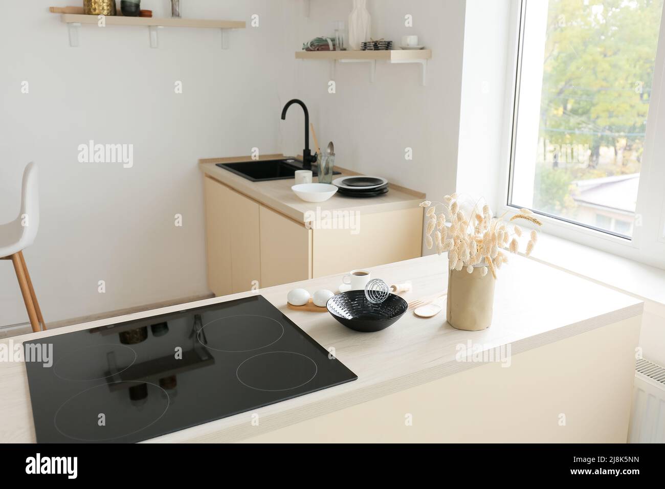 Interior of light kitchen with electric stove and utensils Stock Photo ...