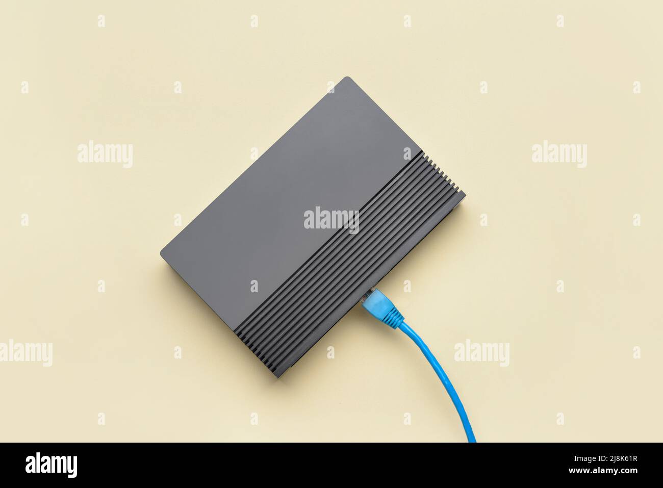 Modern wi-fi router and internet cable on beige background Stock Photo - Alamy