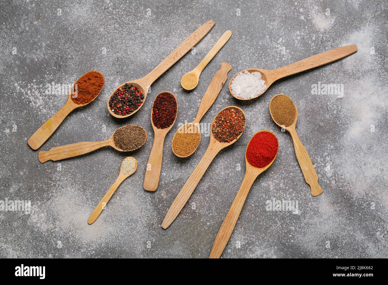 Spoons with aromatic spices on grey background Stock Photo - Alamy