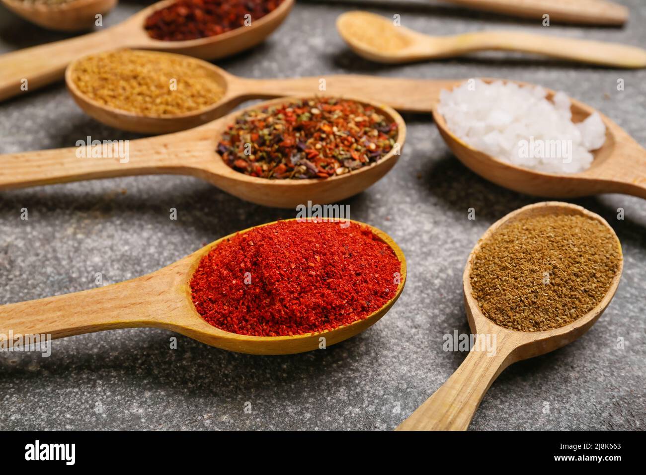 Spoons with aromatic spices on grey background, closeup Stock Photo - Alamy